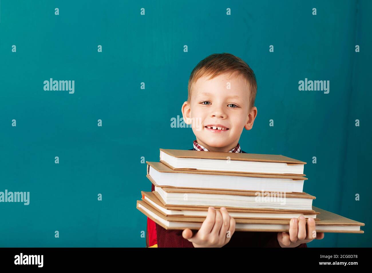 Cheerful thoughtful little school boy in school uniform with backpack ...