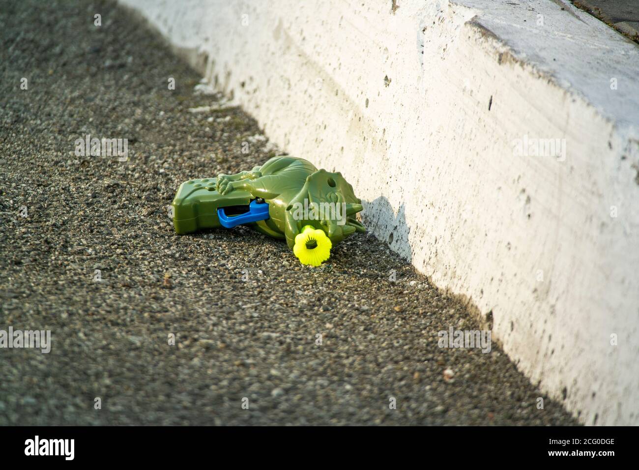 Children's plastic gun for starting soap bubbles lies on the asphalt ...