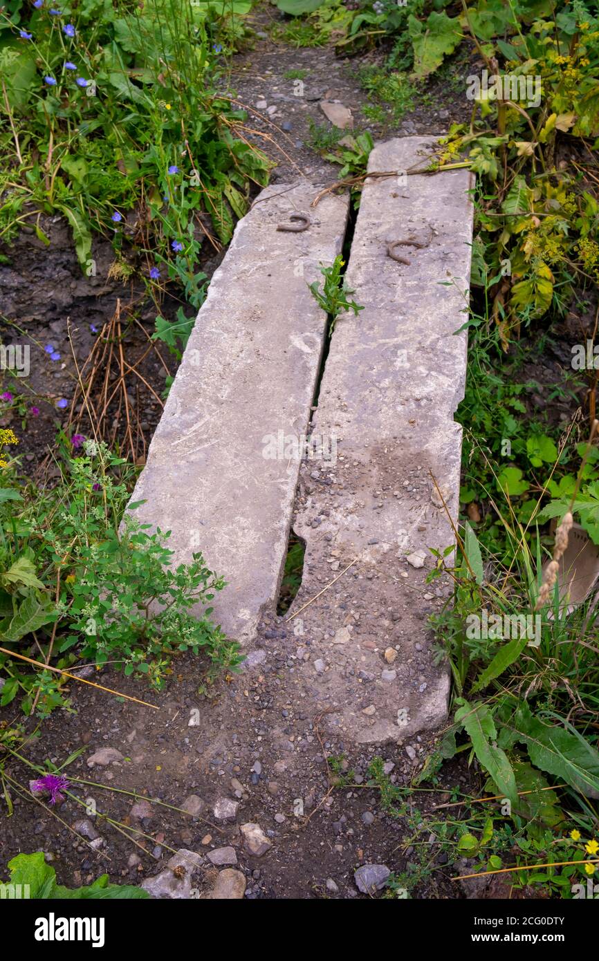 bridge of two concrete blocks across a shallow ditch Stock Photo - Alamy
