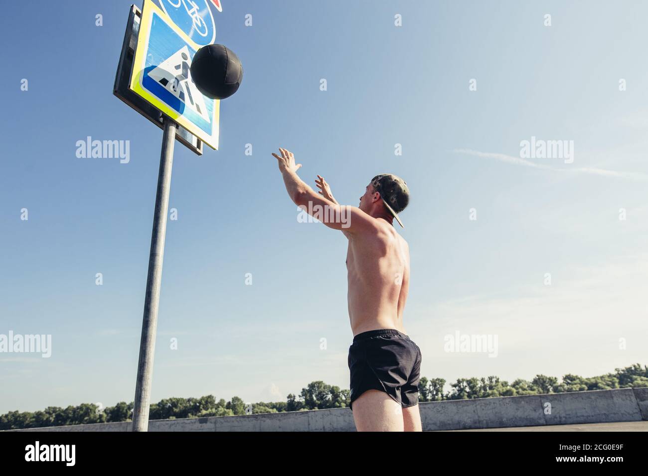 man exercising by throwing a medicine ball up Stock Photo - Alamy