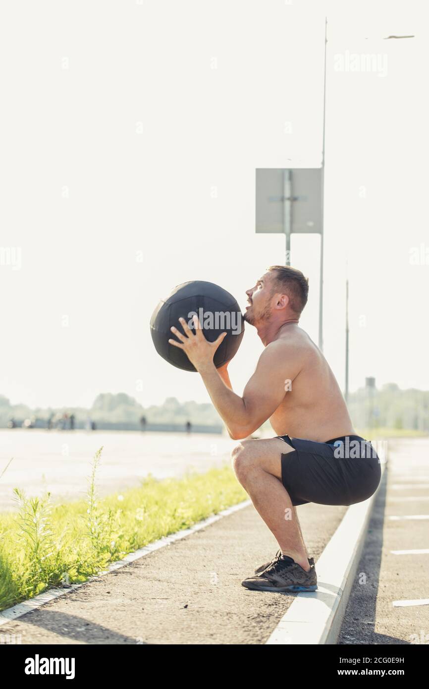 Workout bodyweight exercises using heavy weight ball Stock Photo - Alamy