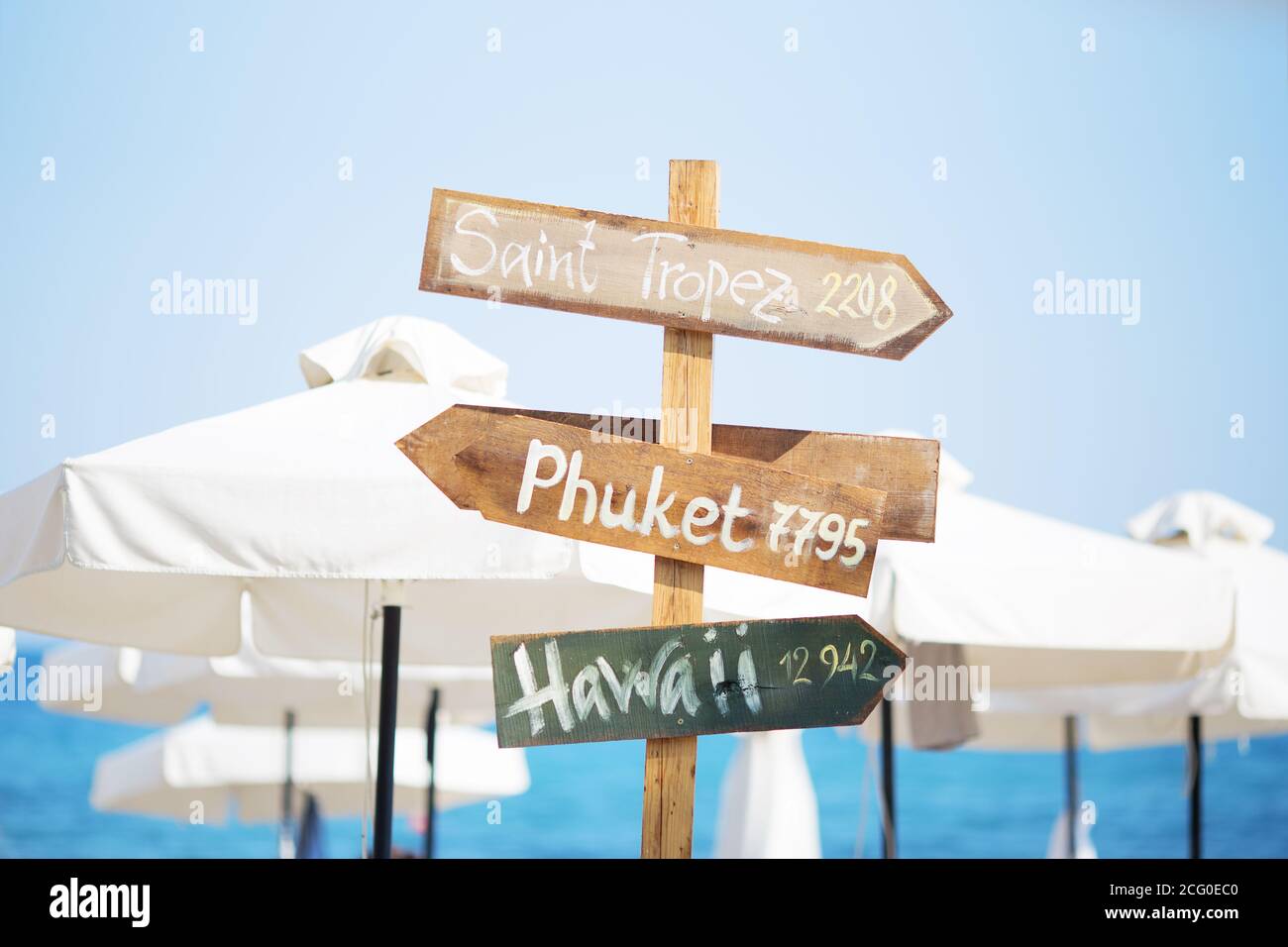 Wooden pointer post with copy space at the beach. arrows on a guidepost ...