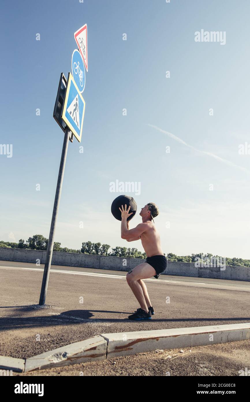 Workout bodyweight exercises using heavy weight ball Stock Photo - Alamy