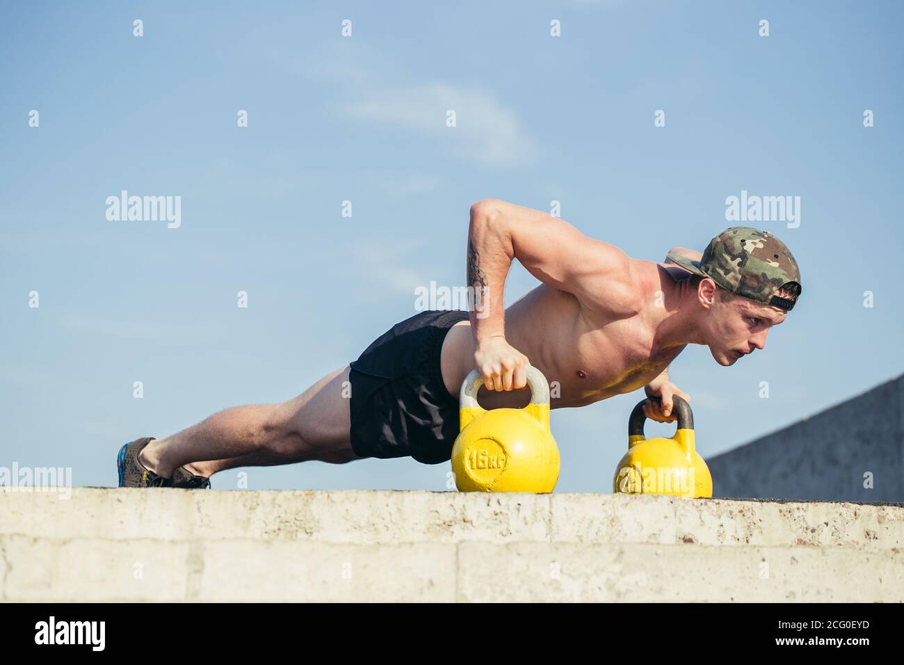 man push-up strength pushup exercise with Kettlebell in workout Stock ...