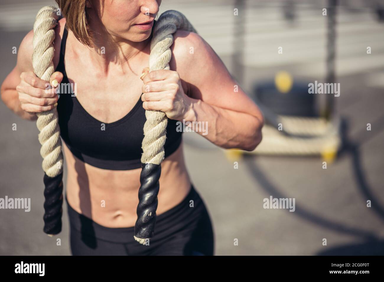 female pushing the prowler exercise equipment. Fit woman exercising at ...
