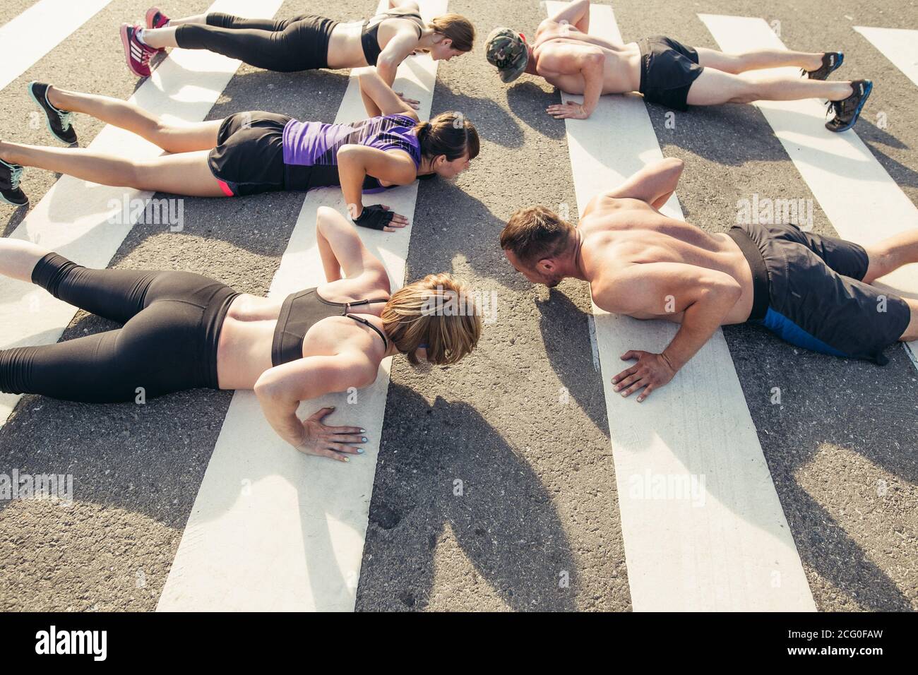 Side view of a group of fitness people doing push ups Stock Photo - Alamy
