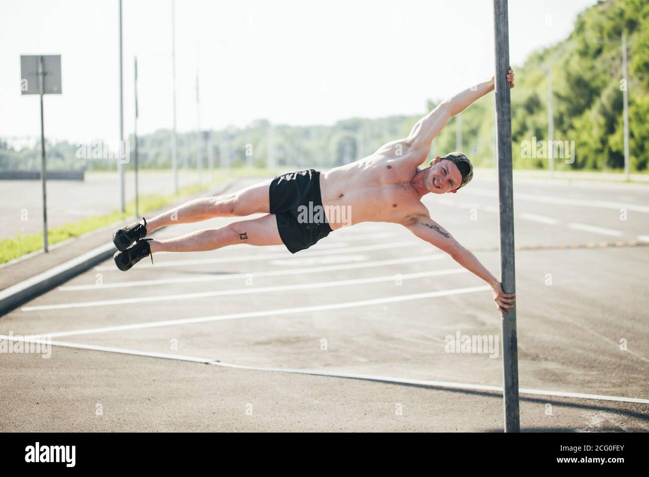 Handstand man workout outdoor push ups on tube Stock Photo - Alamy