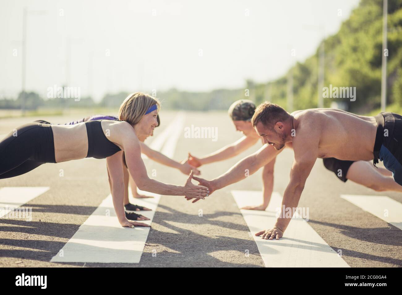 Fit young people focused on planking outdoor Stock Photo - Alamy