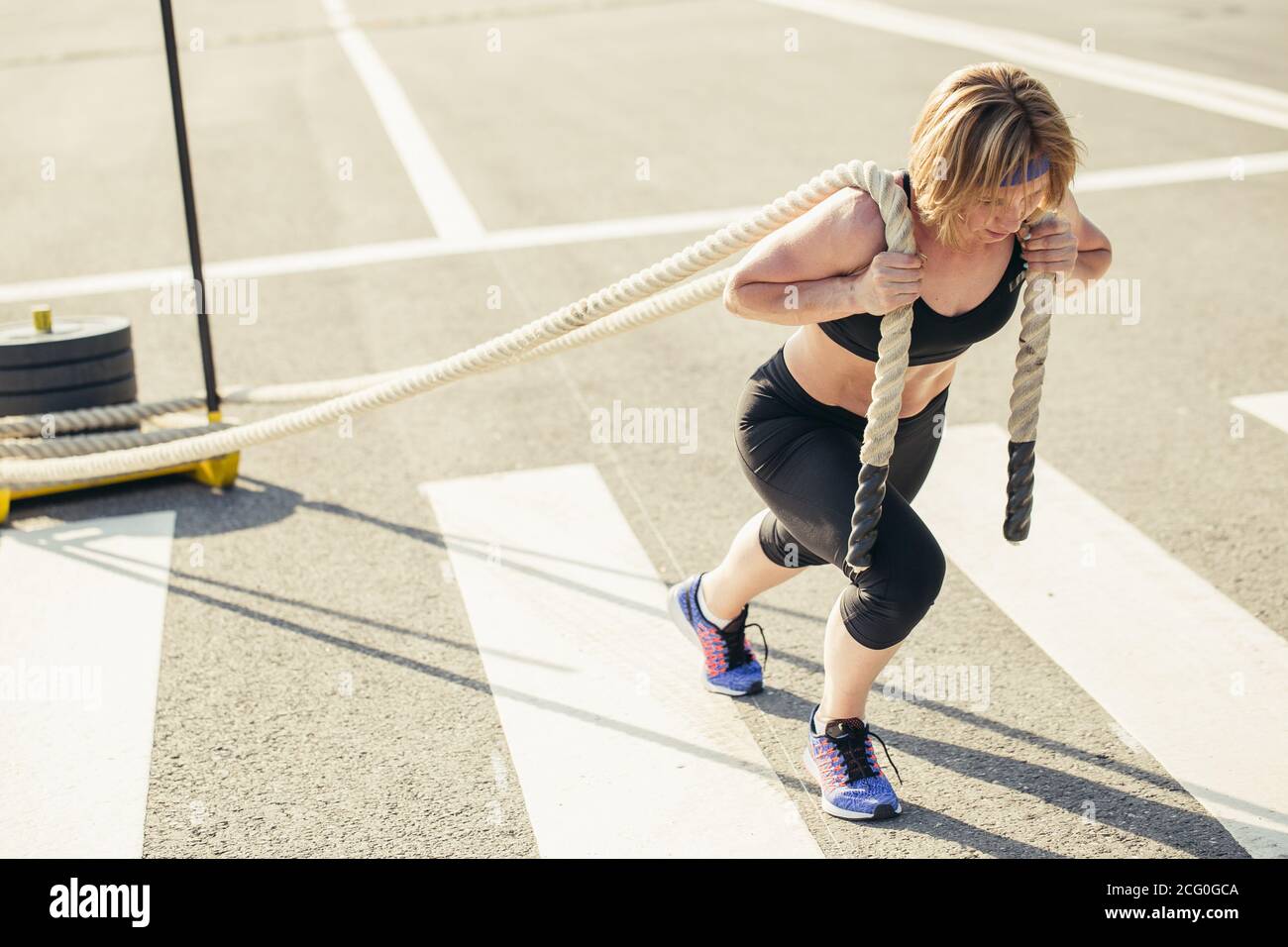 Woman Pulling Cross fit Sled on asphalt Stock Photo - Alamy