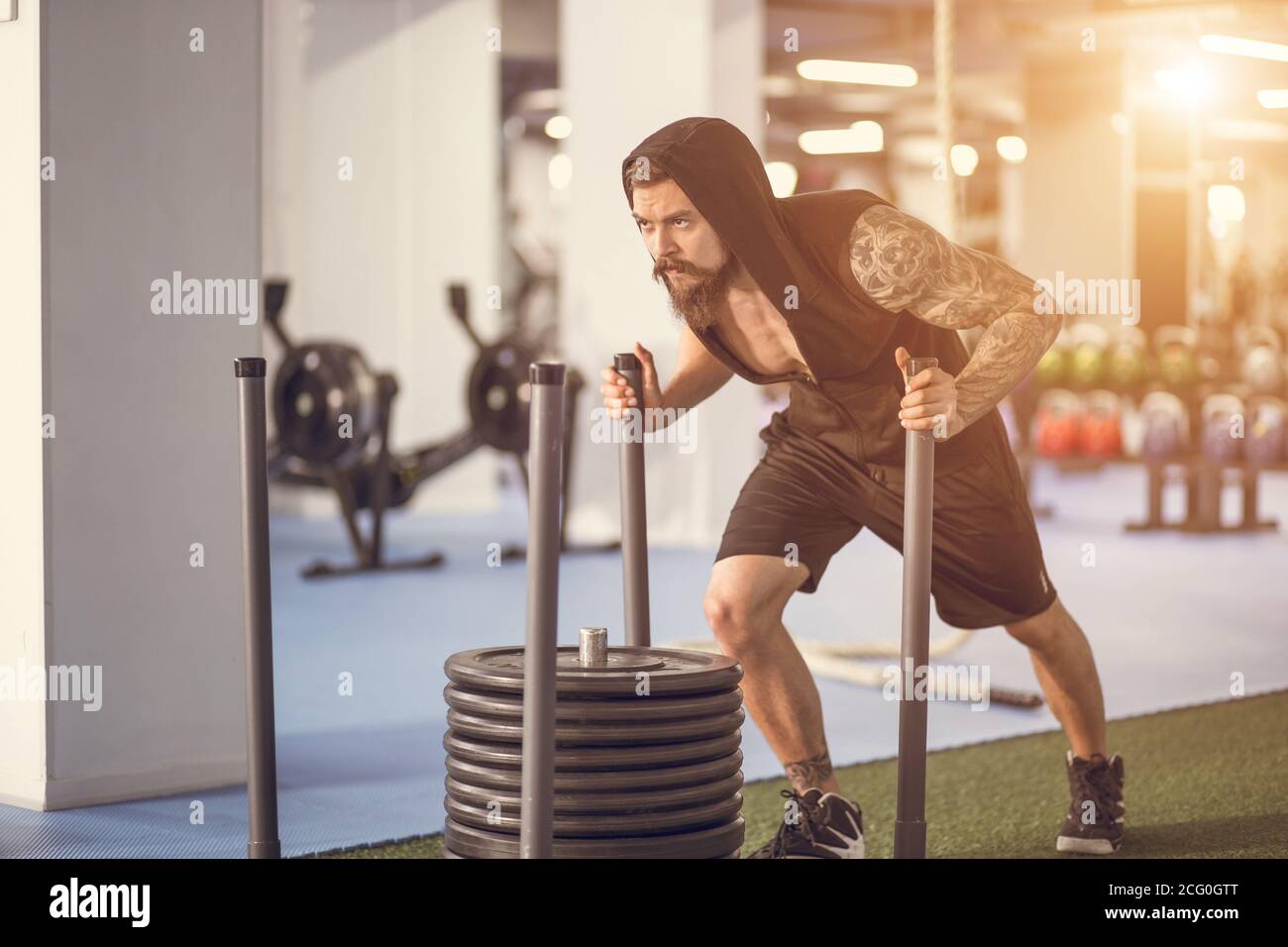sled push man pushing weights workout exercise at gym Stock Photo - Alamy