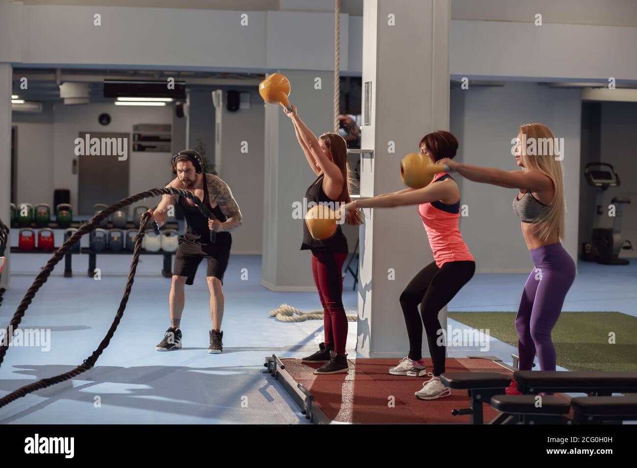 group of fitness people doing exercise with weights, rope, parallel ...