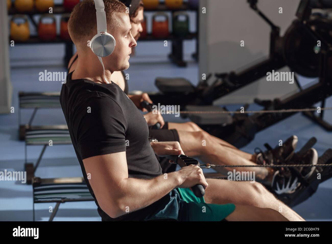 Mid section of people exercising on rowing machine at gym Stock Photo ...