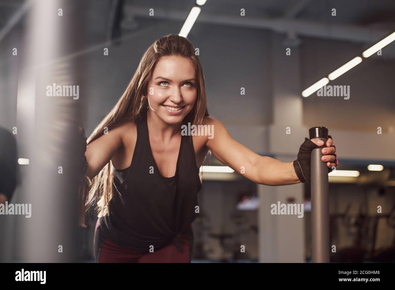 Muscular and strong young female pushing the prowler exercise equipment ...