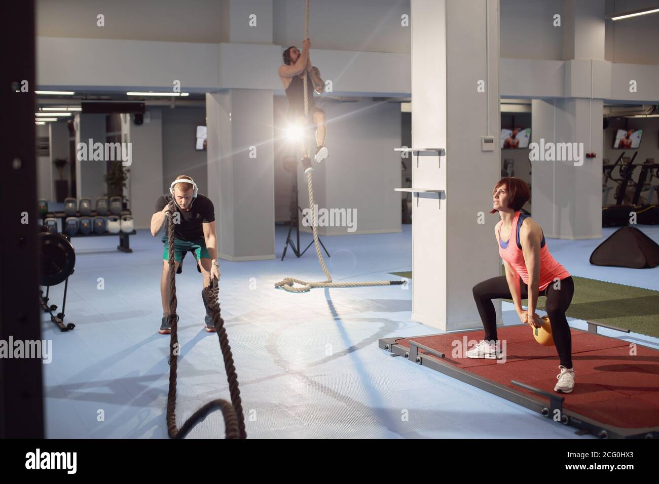group of fitness people doing exercise with weights, rope, parallel ...