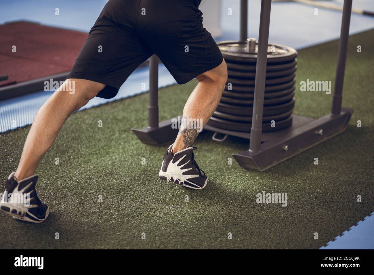 sled push man pushing weights workout exercise at gym Stock Photo - Alamy