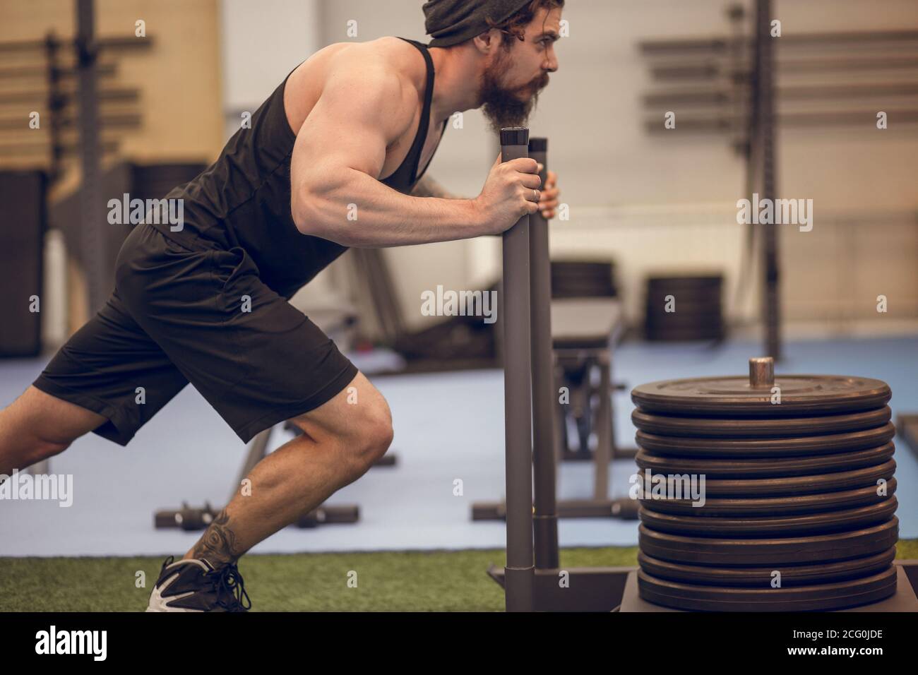 sled push man pushing weights workout exercise at gym Stock Photo - Alamy