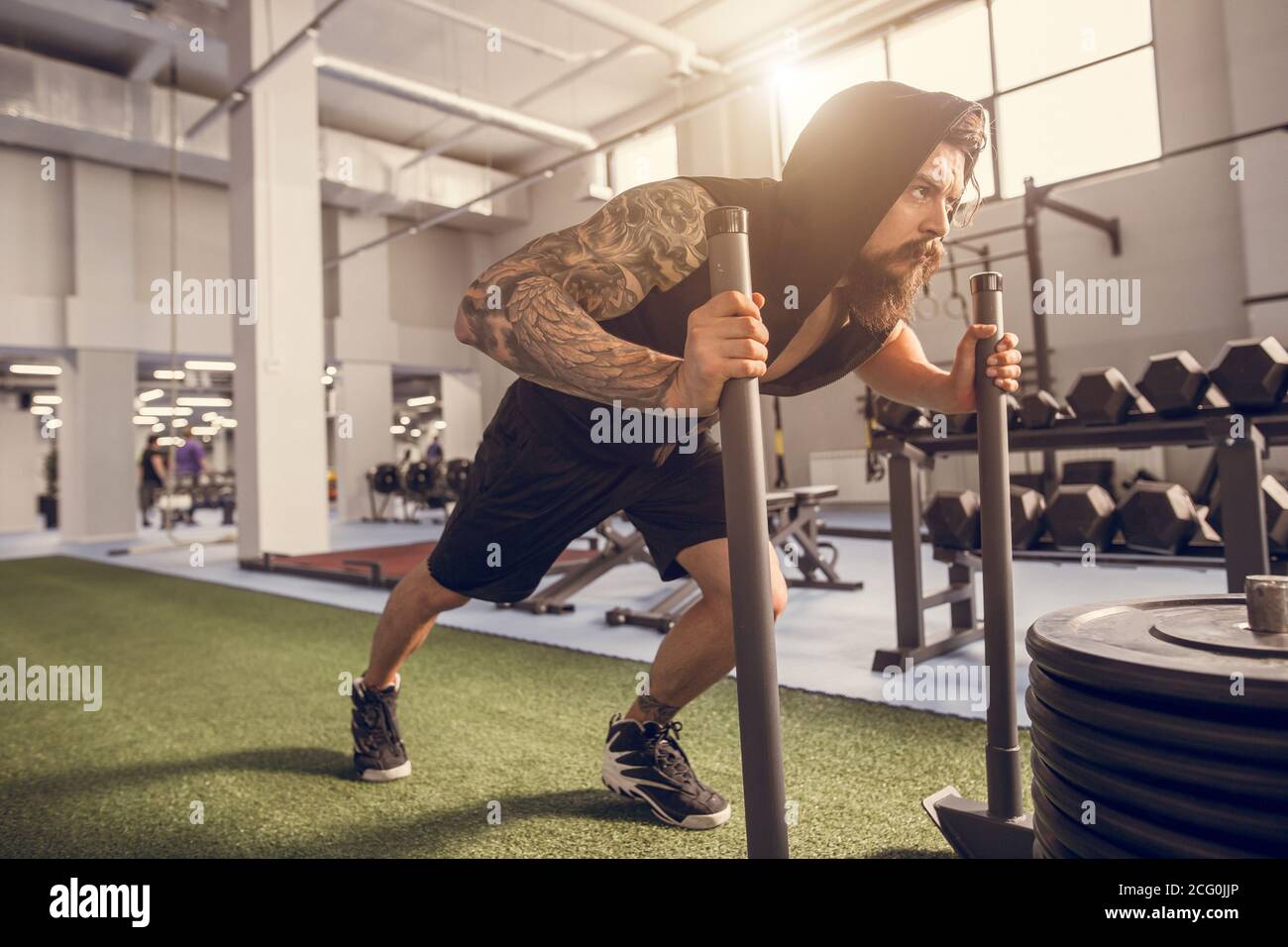 sled push man pushing weights workout exercise at gym Stock Photo - Alamy