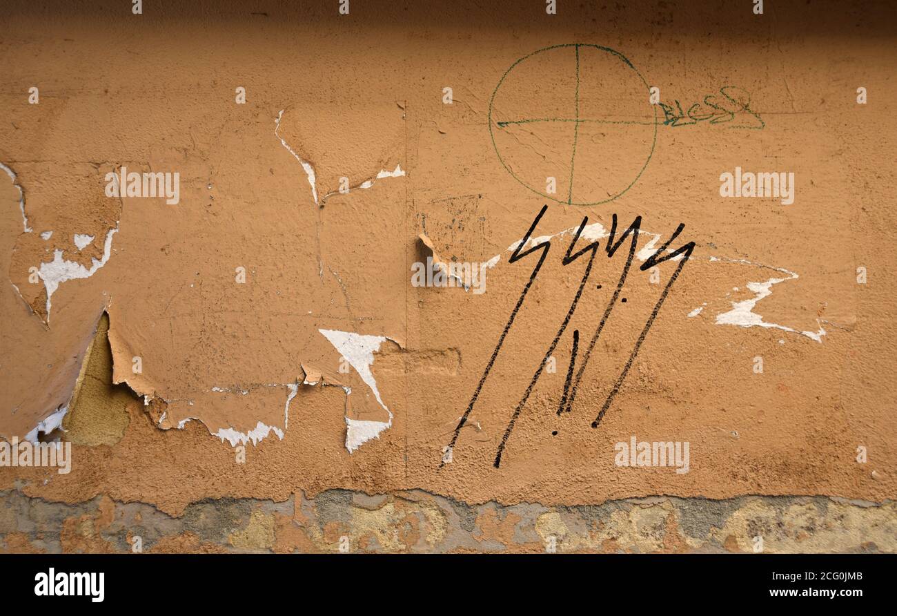 Enigmatic markings and graffiti mark old weathered walls of buildings ...