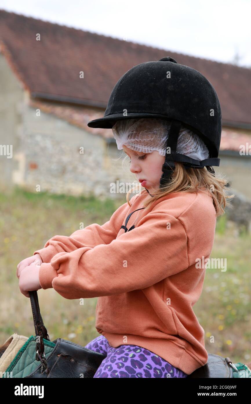 Little girl pony riding at a stables, France Stock Photo - Alamy