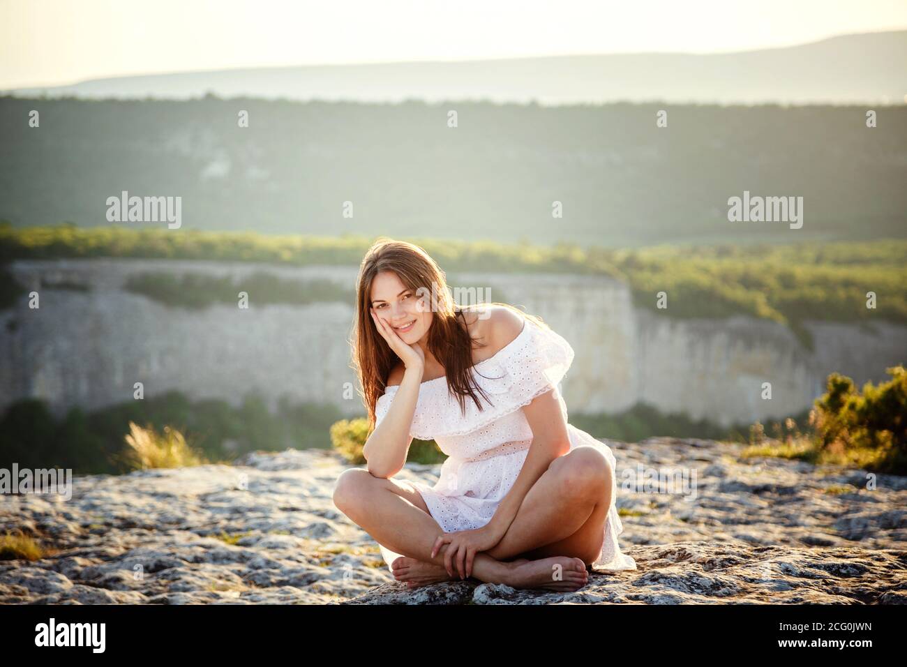 beautiful young woman in a white dress enjoys stunning scenery in the ...