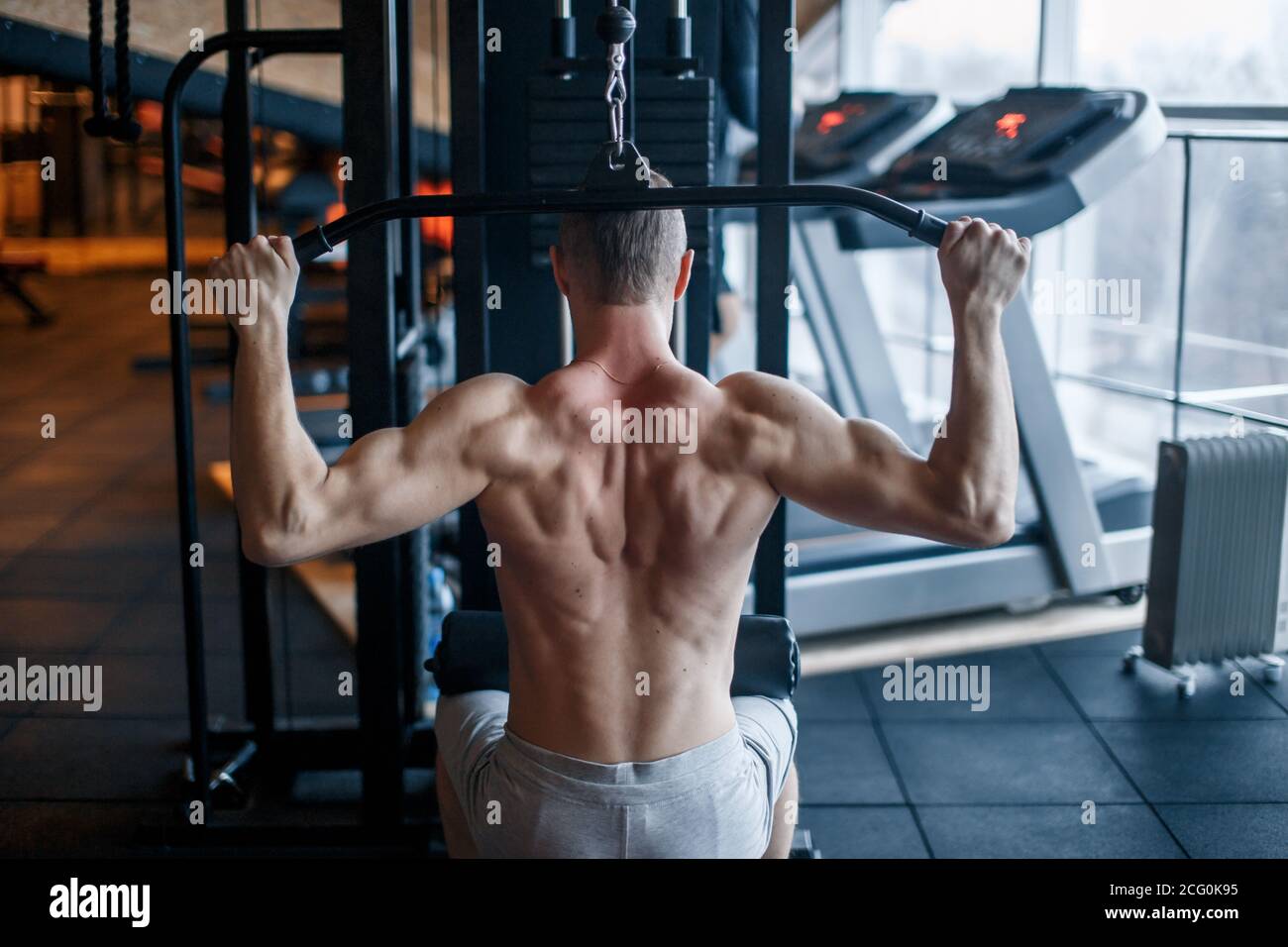 Shoulder pull down machine. Fitness man working out lat pulldown ...