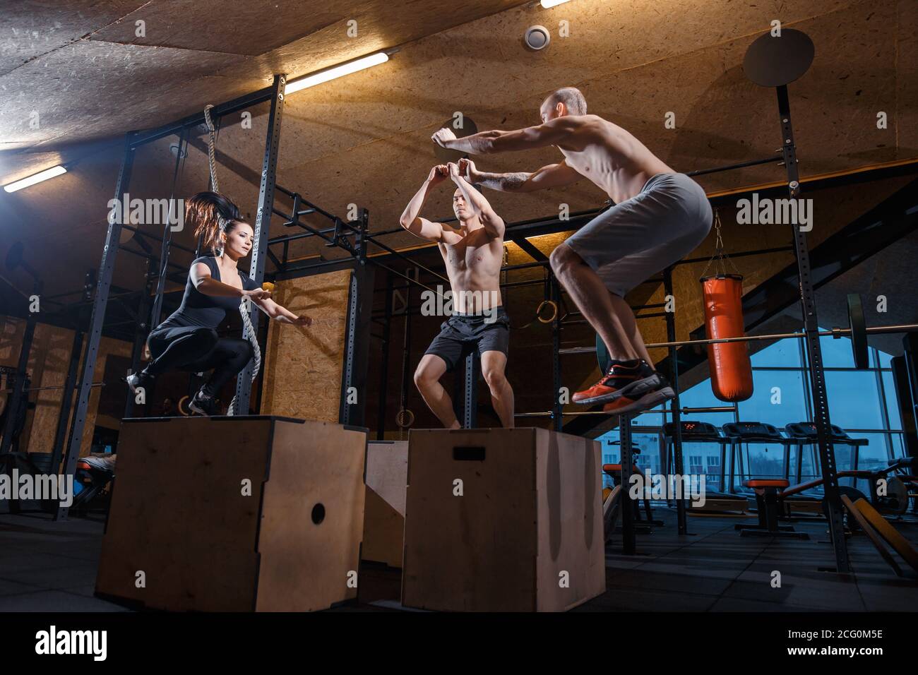 Male and female athletes doing box jumps at gym Stock Photo - Alamy