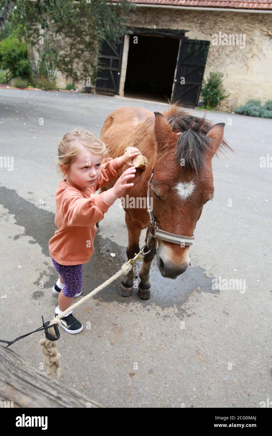 Little girl pony riding at a stables, France Stock Photo - Alamy