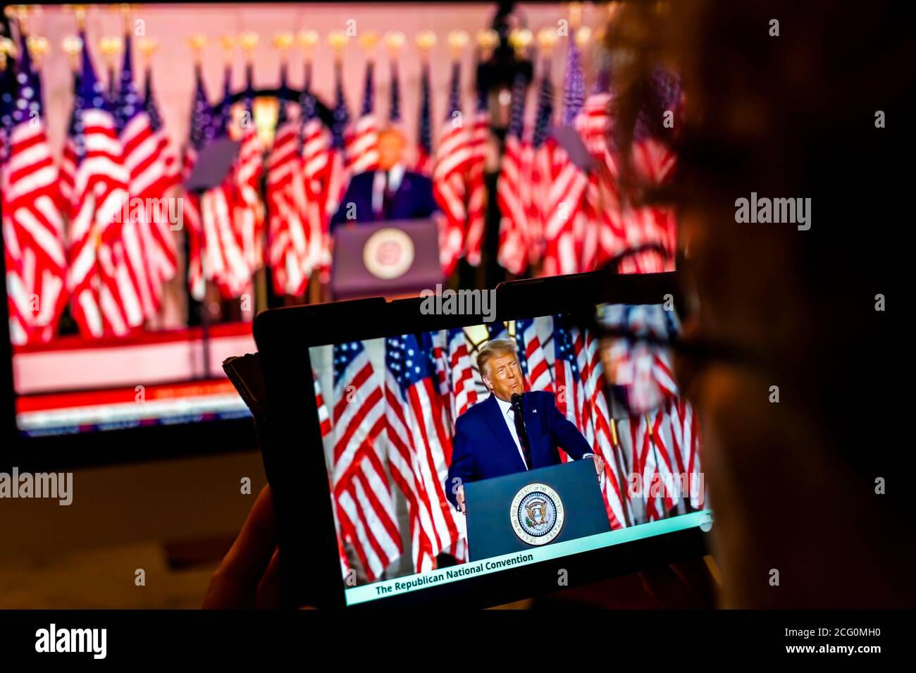 A voter watches President Donald Trump give his acceptance speech at ...