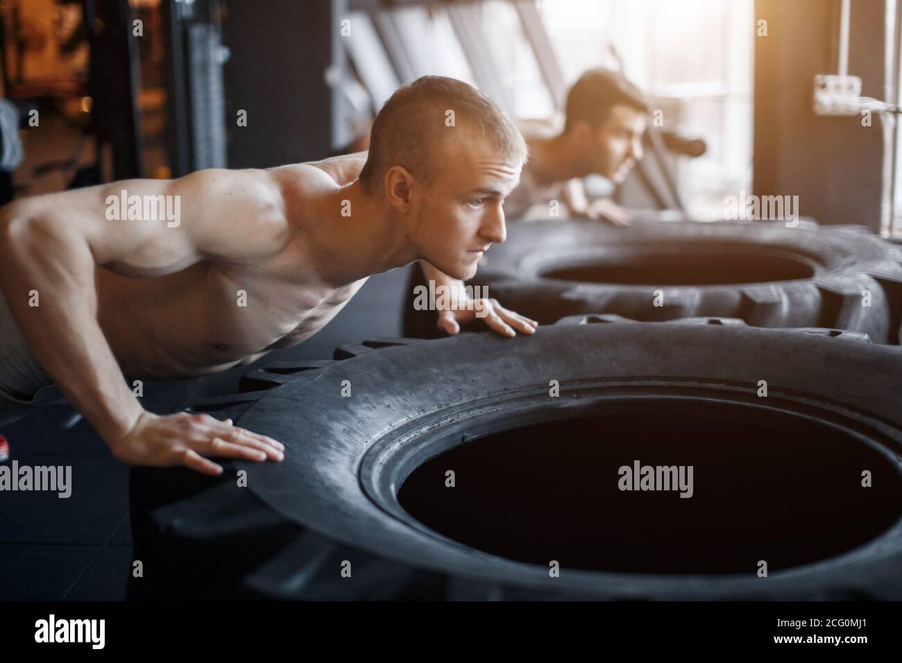 Push up on a tire cross fit training Stock Photo - Alamy