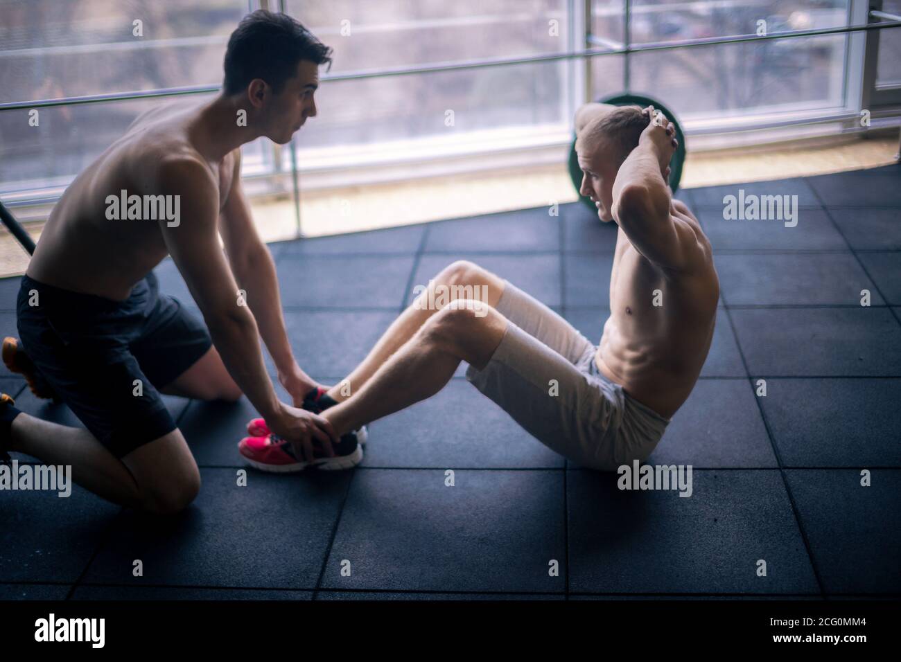 Fit mens doing sit-ups on exercise mats at fitness club Stock Photo - Alamy