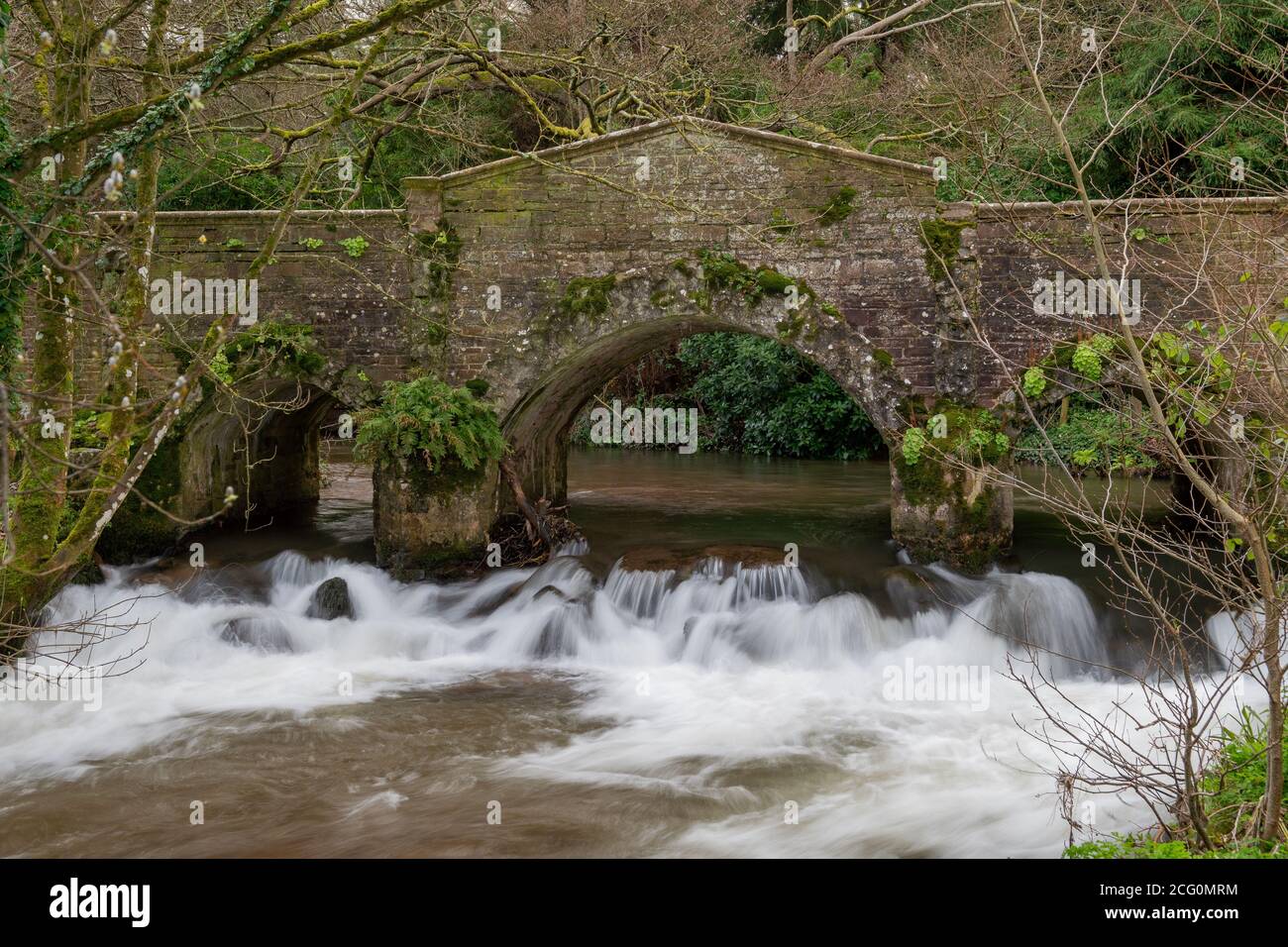 Long exposure of the River Avill flowing under a bridge in Dunster ...