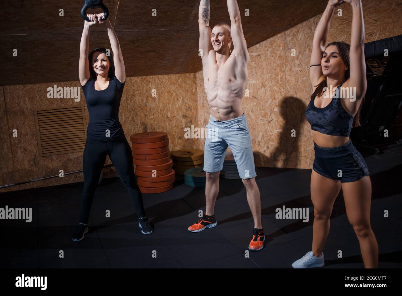 Group having functional fitness training with kettlebell in sport gym ...