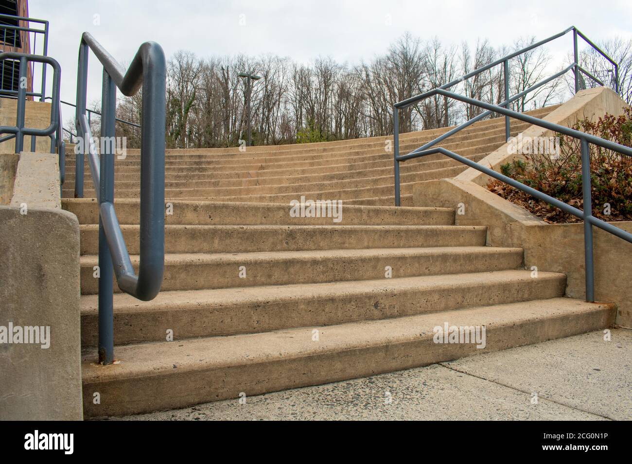 A Set of Small Concrete Steps With a Green Railing in a Shopping Center ...