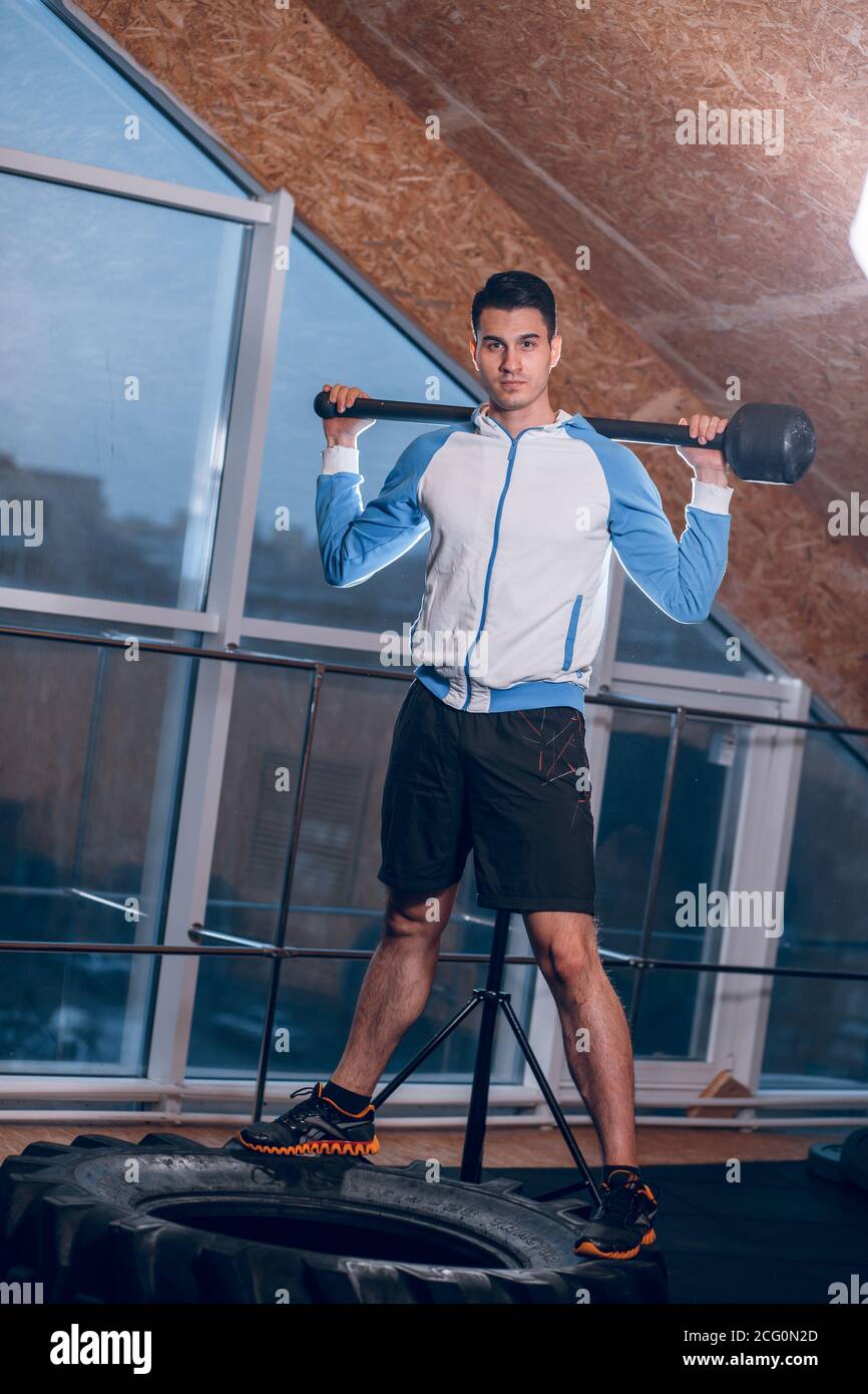 two Male fitness models training workout witth heavy and big tire and ...