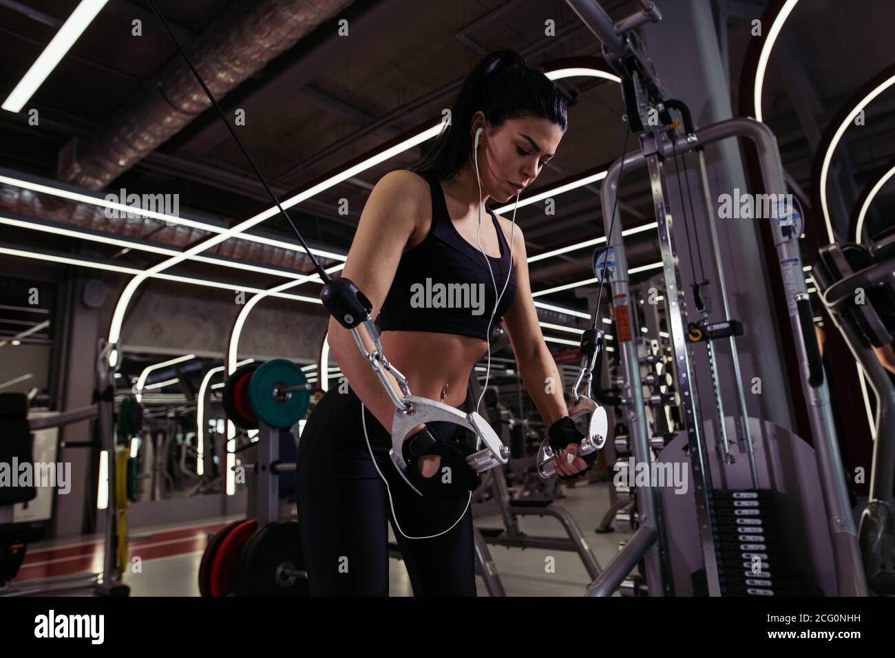 fit woman exercise with exercise-machine Cable Crossover in gym Stock ...