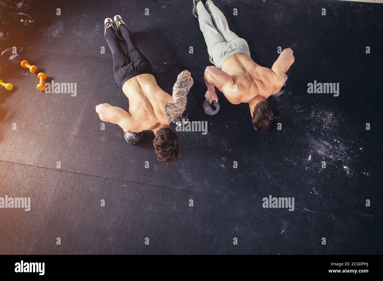 Gym two man push-up strength pushup exercise with Kettlebell in a ...