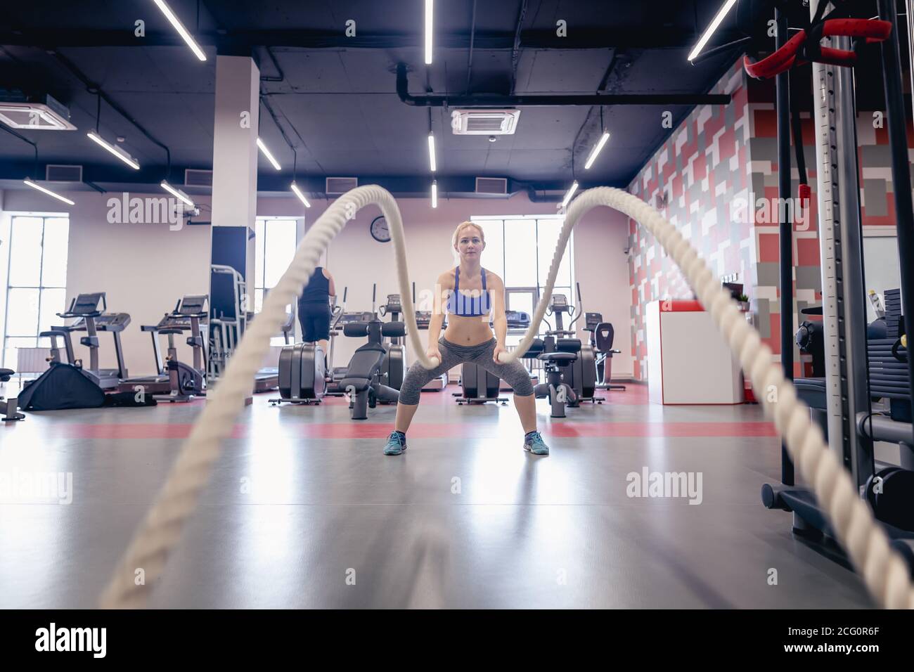 battling ropes girl at gym workout exercise fitted body Stock Photo - Alamy