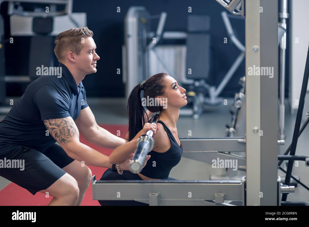 Personal trainer and fit woman working with barbell Stock Photo - Alamy