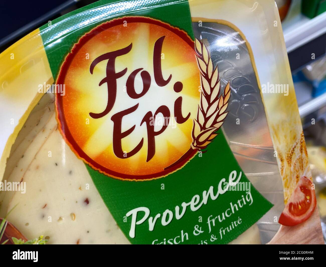 Viersen, Germany - July 9. 2020: View on packet Fol Epi cheese hold by hand in front of shelf in ...