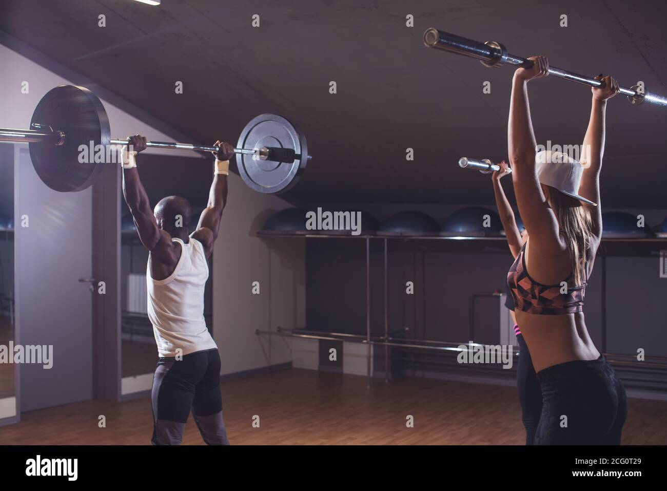 Athletes friends training with barbells inside gym club - Young people ...