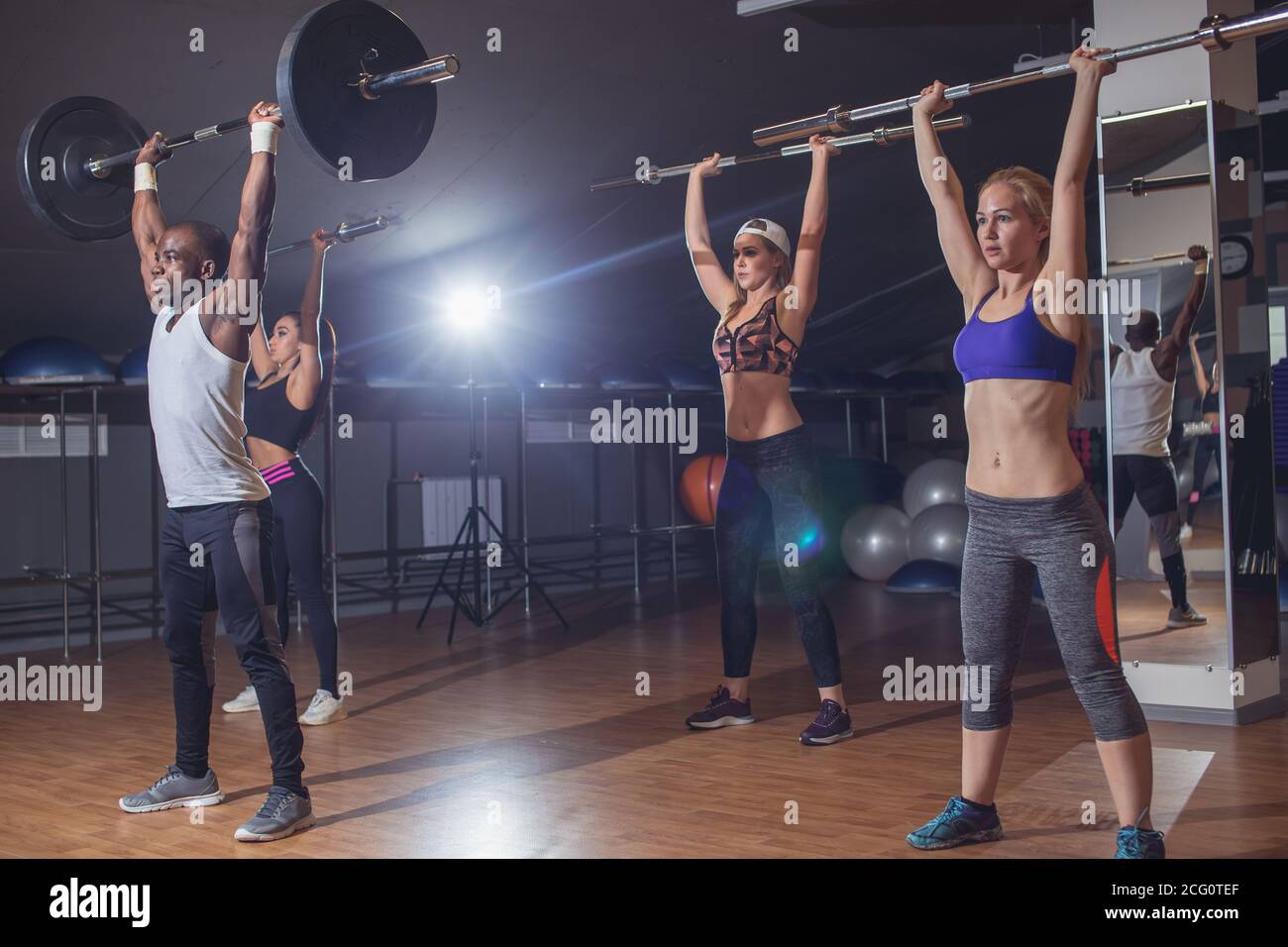 Athletes friends training with barbells inside gym club - Young people ...