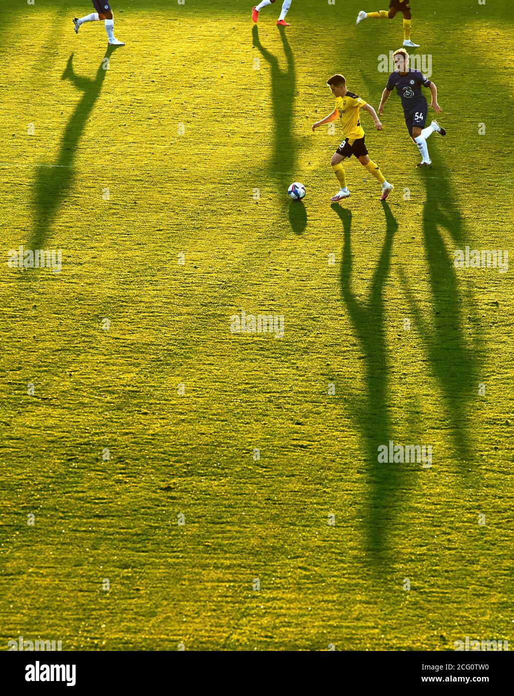 A general view of play as the sun casts long shadows over the pitch ...
