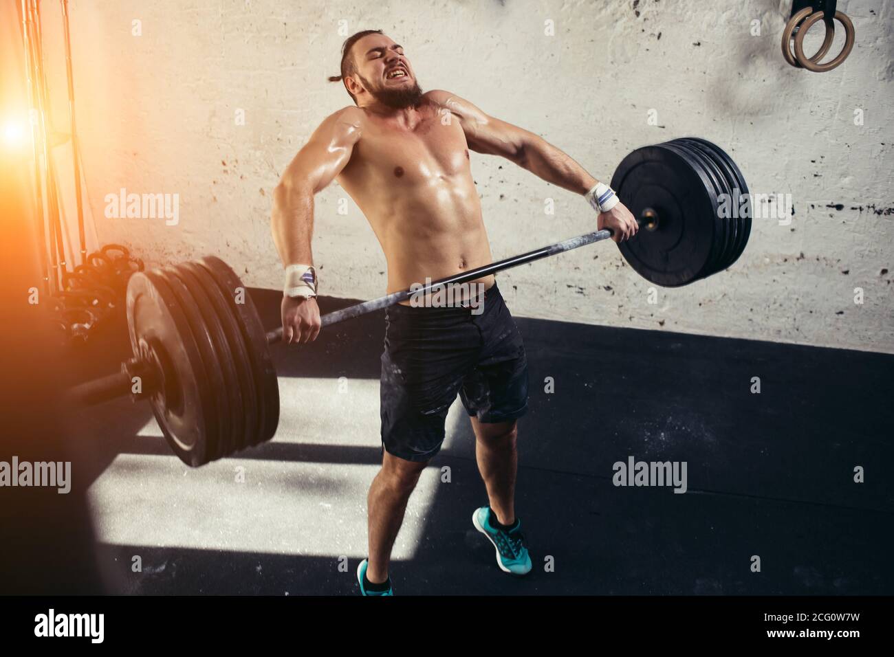 strong cross fit athlete in the middle a heavy snatch lift in a cross ...
