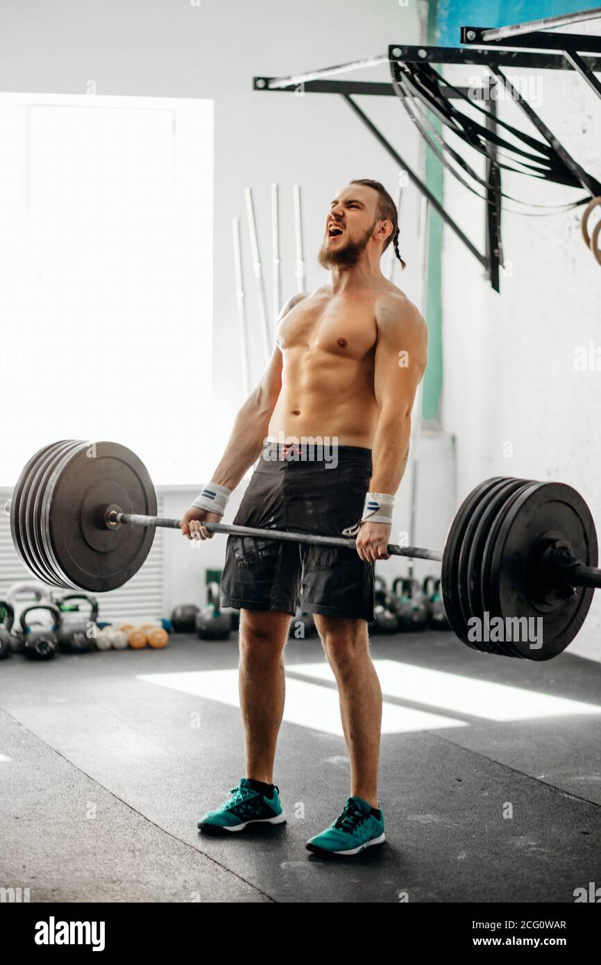 strong crossfit athlete in the middle a heavy snatch lift in a cross ...