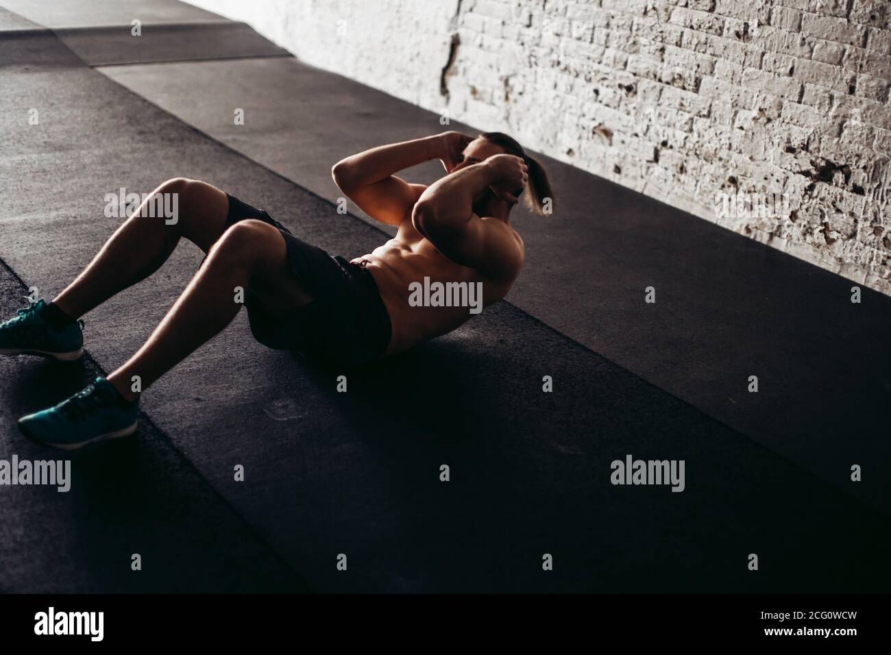 Male fitness model doing sit ups and crunches exercising abdominal ...