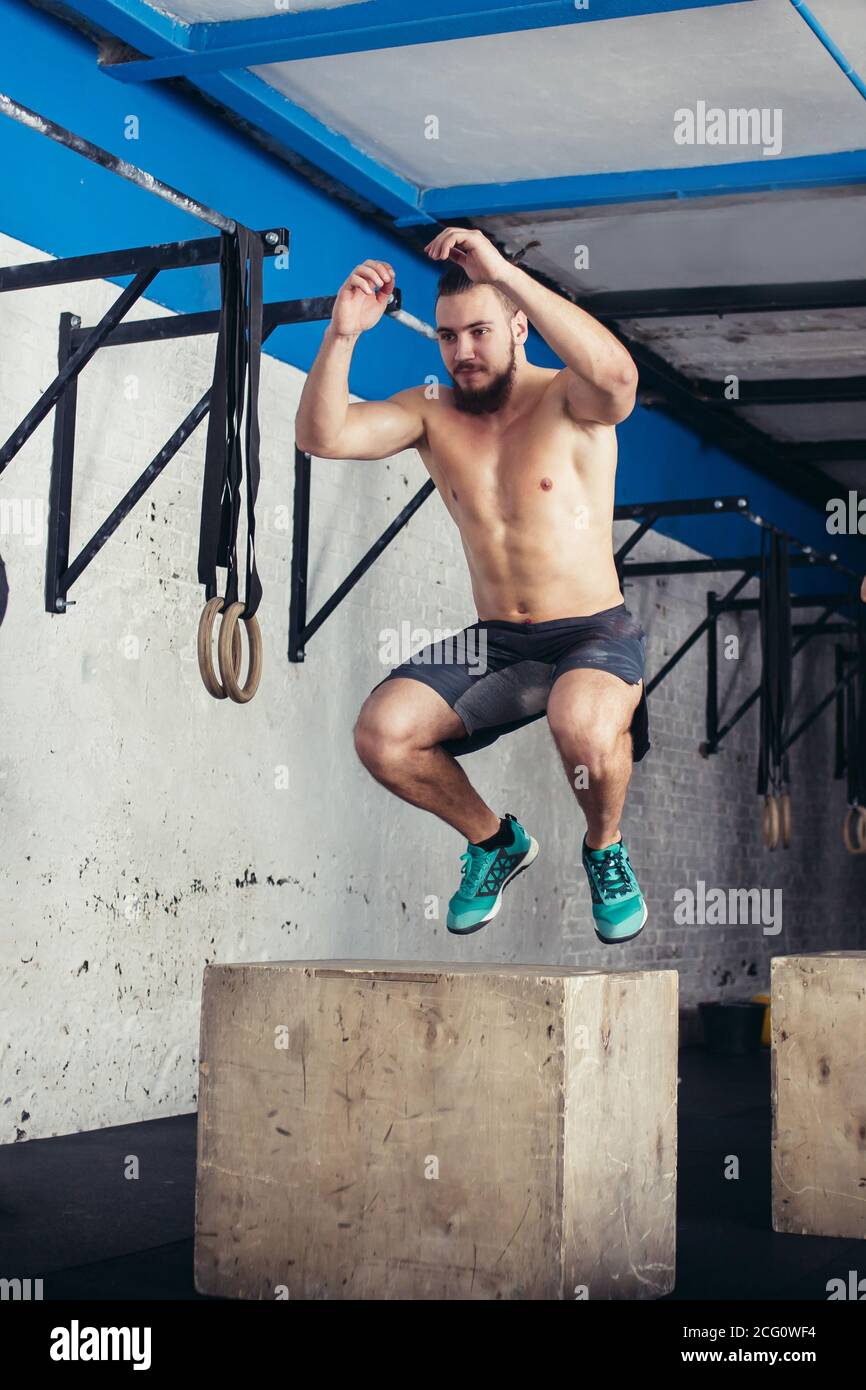 Fit young people doing box jumps in a gym Stock Photo - Alamy