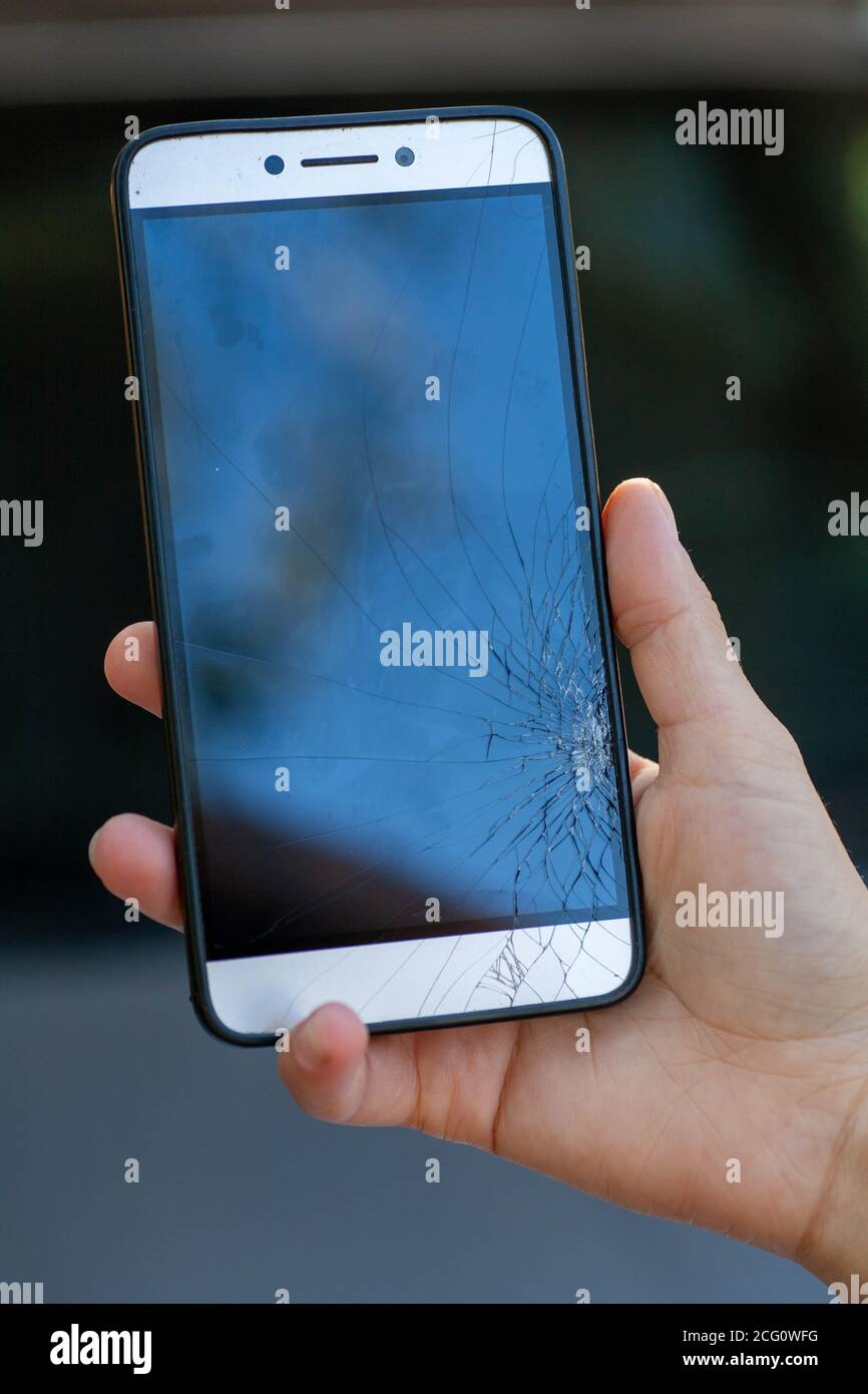 Broken glass of smart phone. Selective focus. the girl holds in her ...
