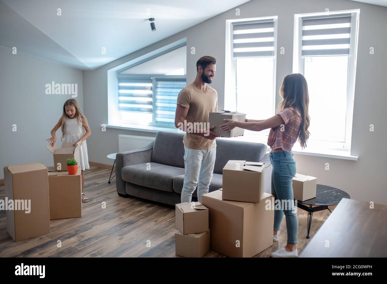 Family unpacking their stuff in a new house Stock Photo - Alamy