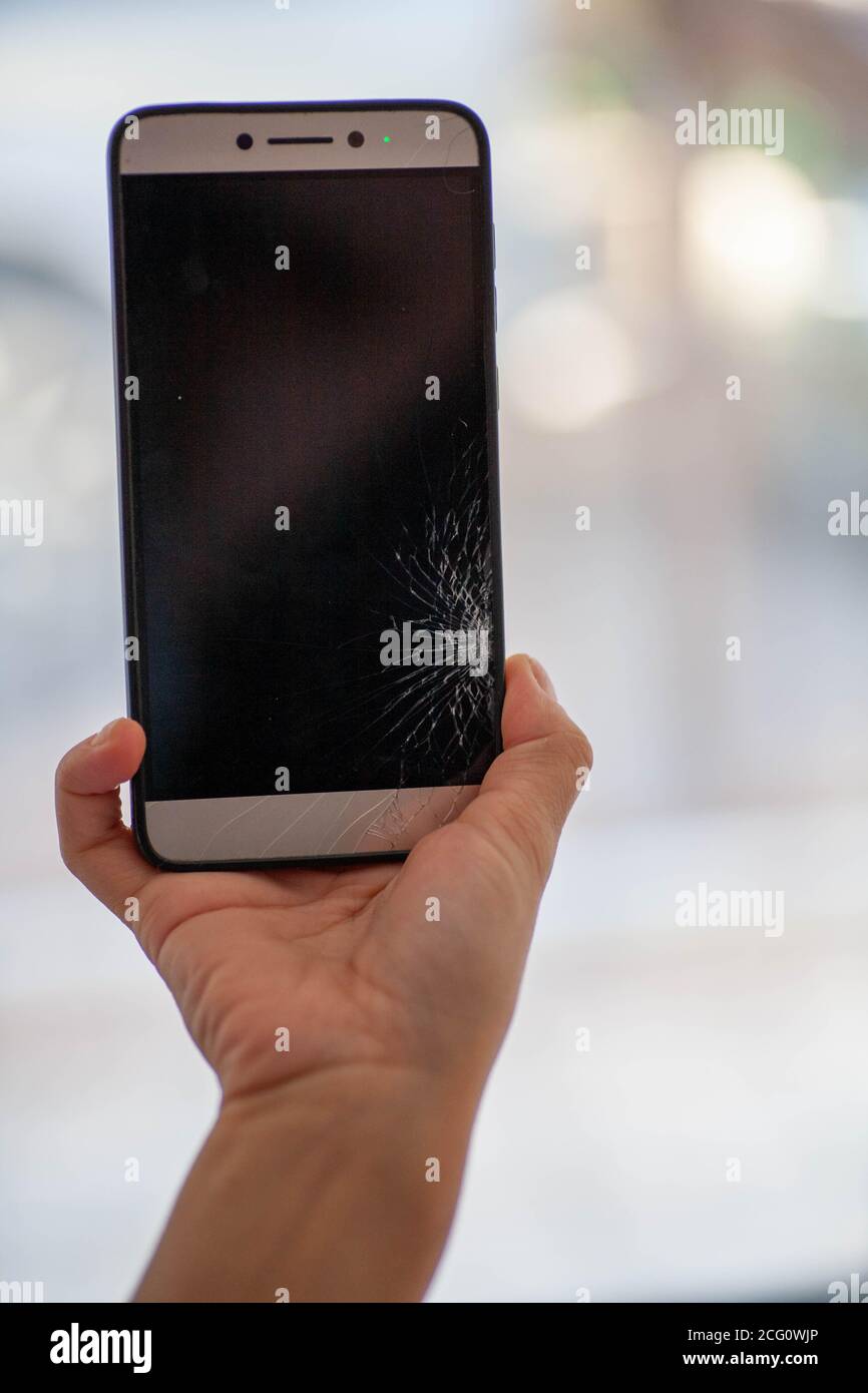 Broken glass of smart phone. Selective focus. the girl holds in her ...