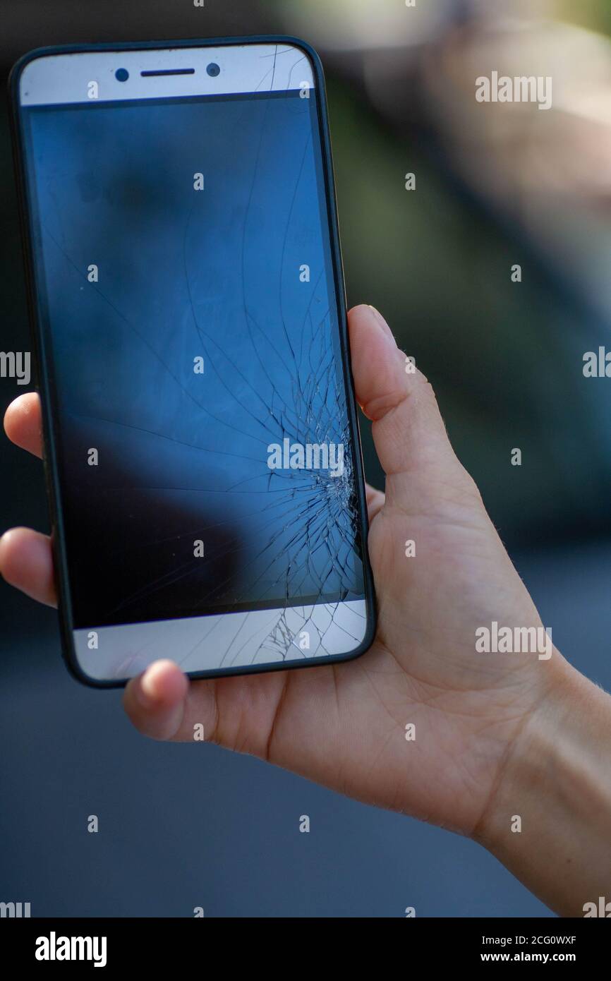 Broken glass of smart phone. Selective focus. the girl holds in her ...